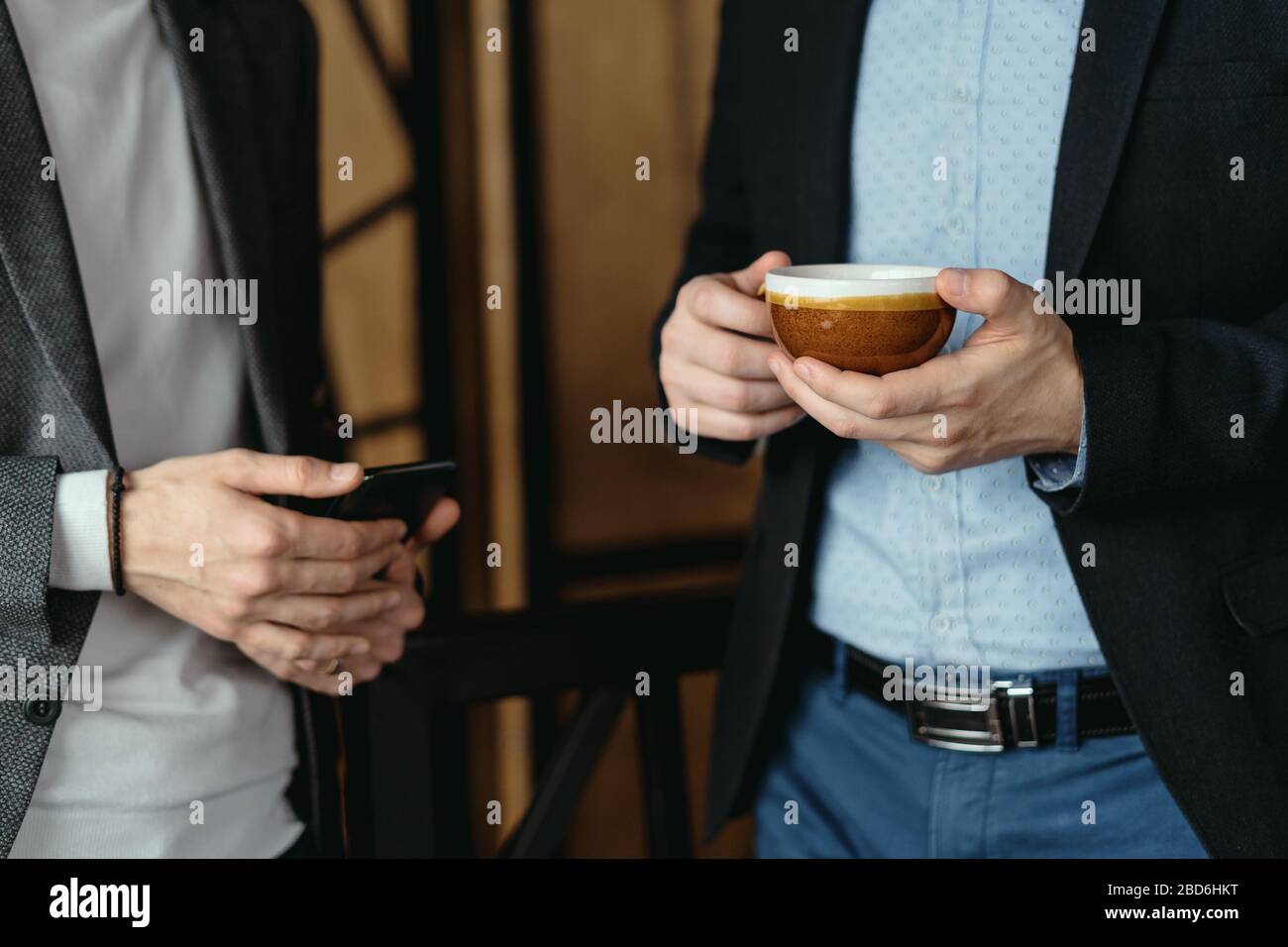 Two businessmen having a chat while standing for a break in a loft ...