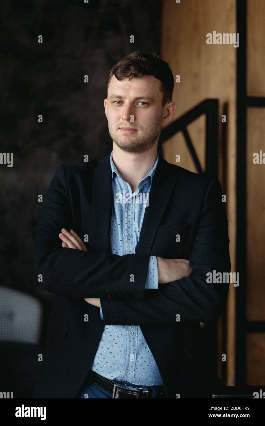 Executive manager portrait looking at camera standing in modern loft ...