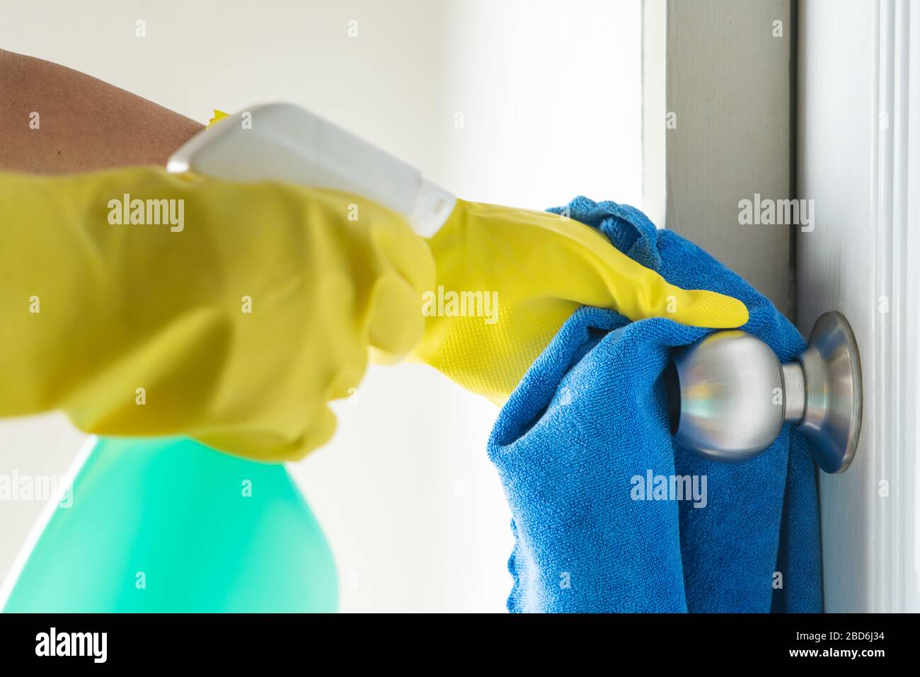Cleaning door knob with alcohol spray for Covid-19 Coronavirus ...