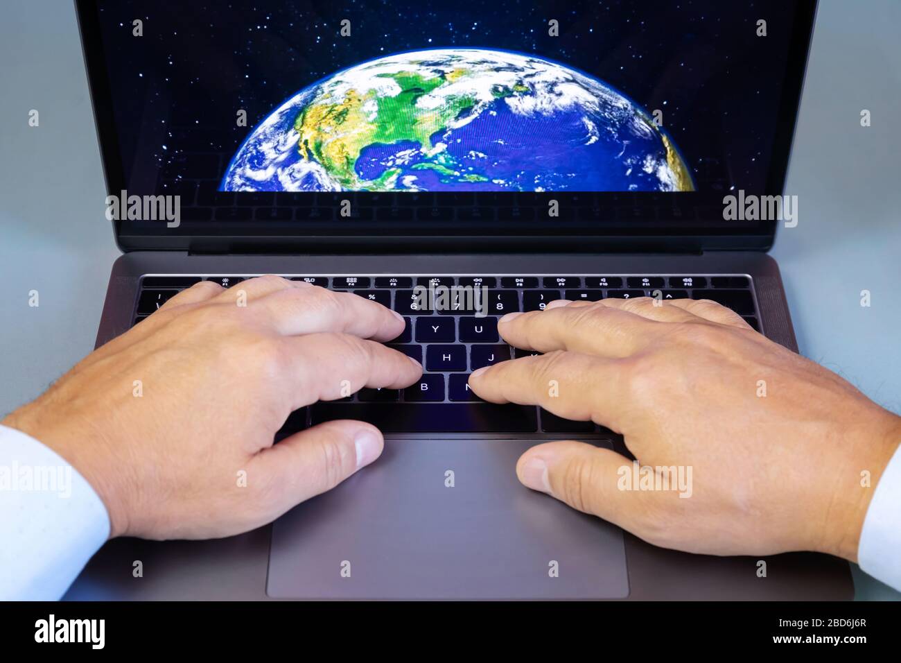 A man types on the keyboard of an Apple laptop, Macbook pro series. The ...