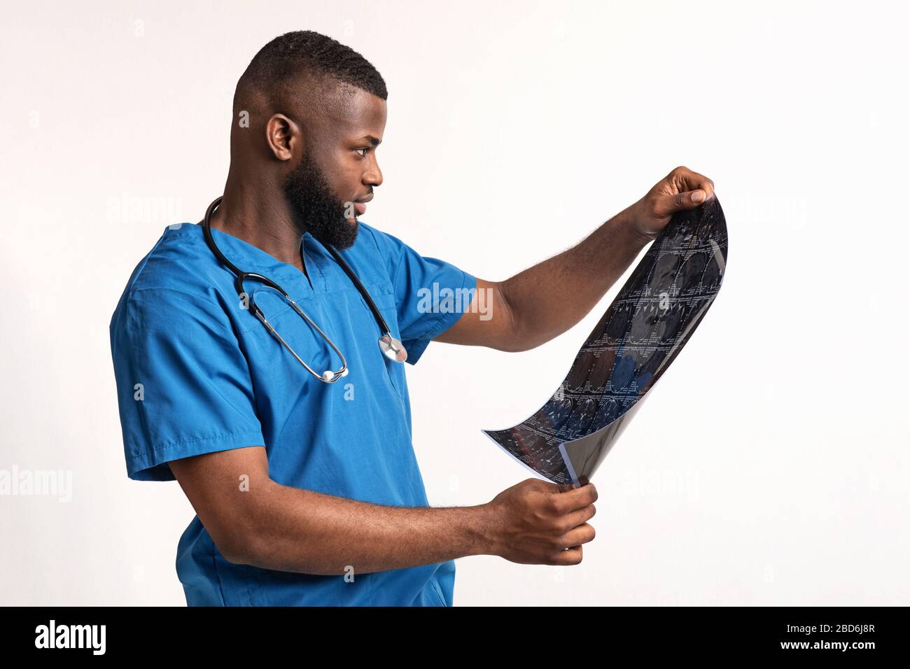 Young medical doctor analyzing CT scan on white background Stock Photo ...
