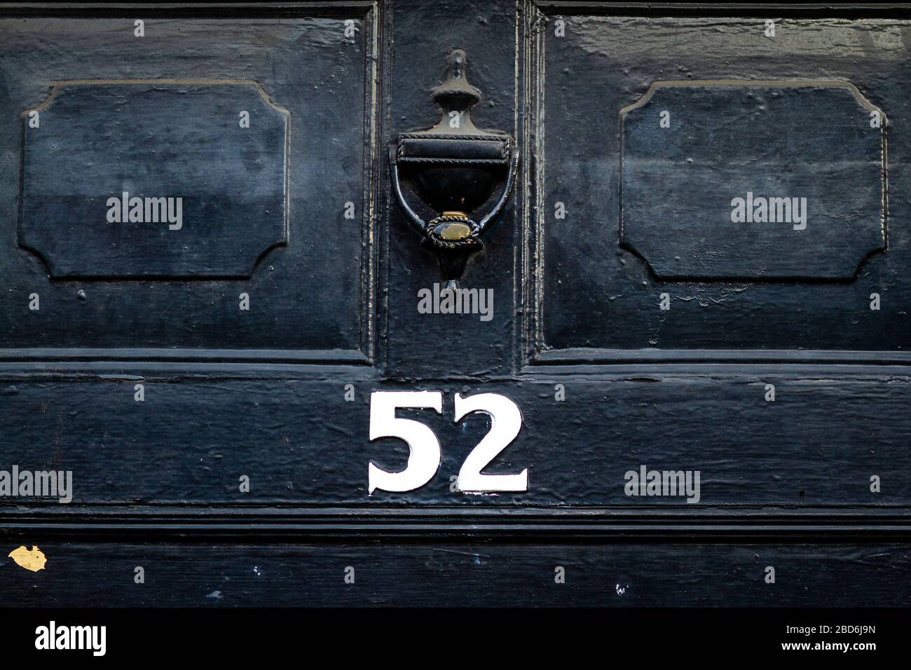 House number 52 on a black wooden front door in London Stock Photo - Alamy