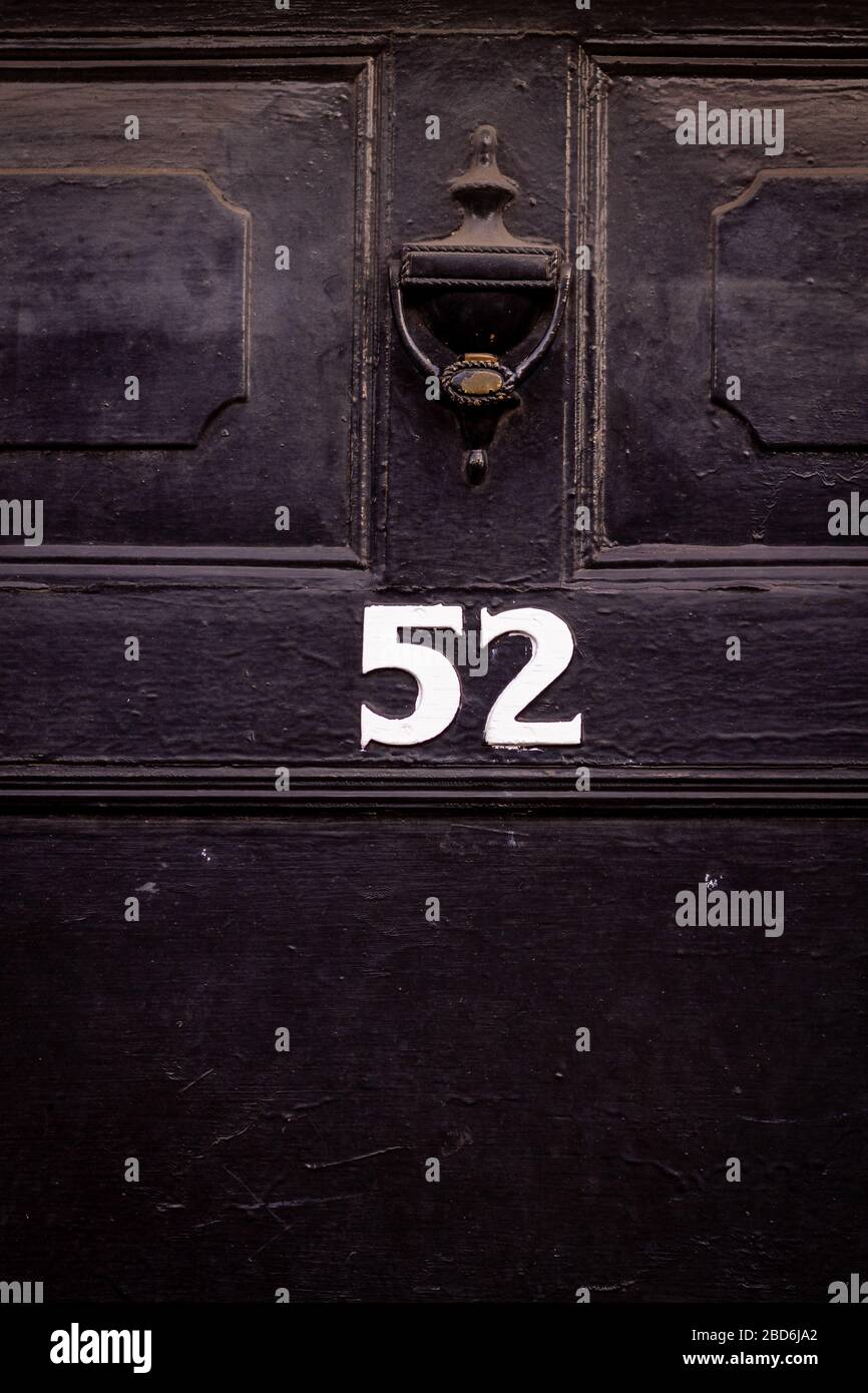 House number 52 on a black wooden front door in London Stock Photo - Alamy