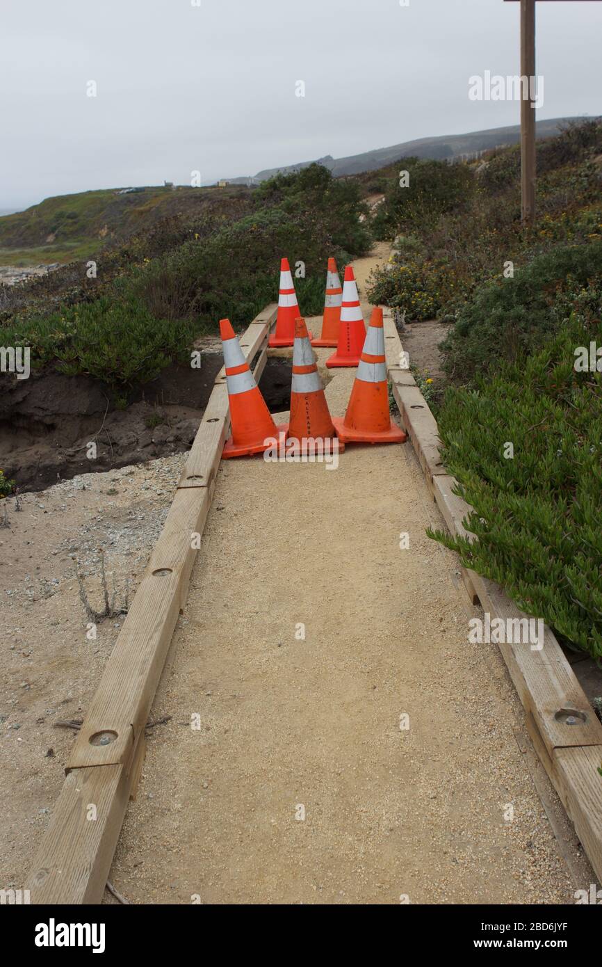 Orange construction cones warning people not to fall down the hole in ...