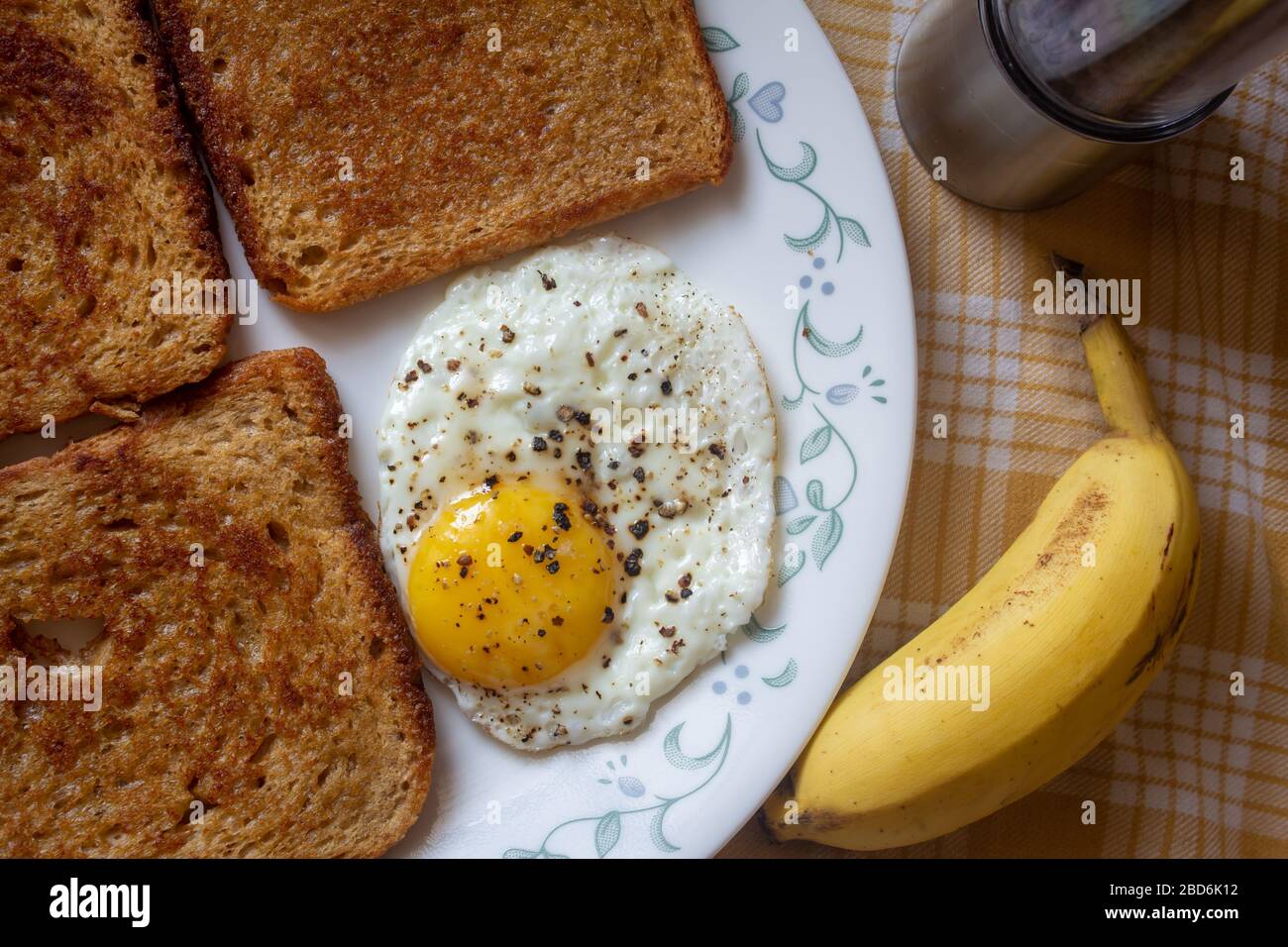Butter toasted wheat bread with bulls eye egg. Sunny side up egg with ...