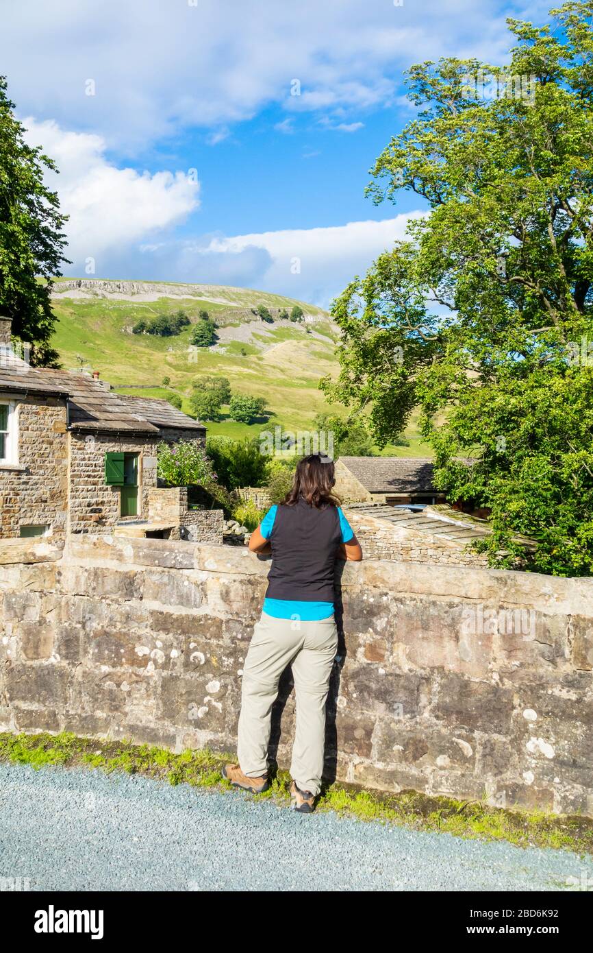 Female walker, hiker on bridge over the river Swale in Swaledale ...