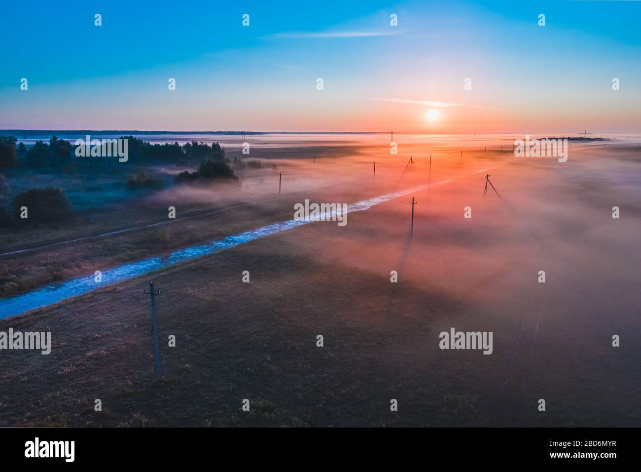 Beautiful bright sunrise in the fields of Belarus with fogs on a summer ...