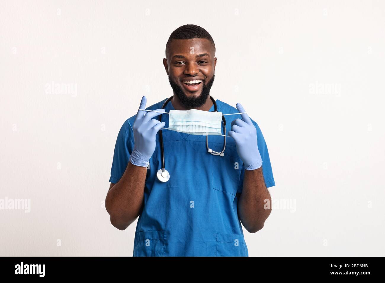 Positive african male doc wearing face mask Stock Photo - Alamy