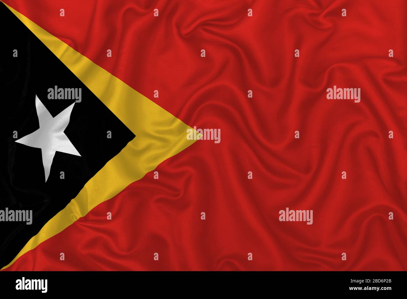 East Timor country flag on wavy silk textile fabric background Stock ...