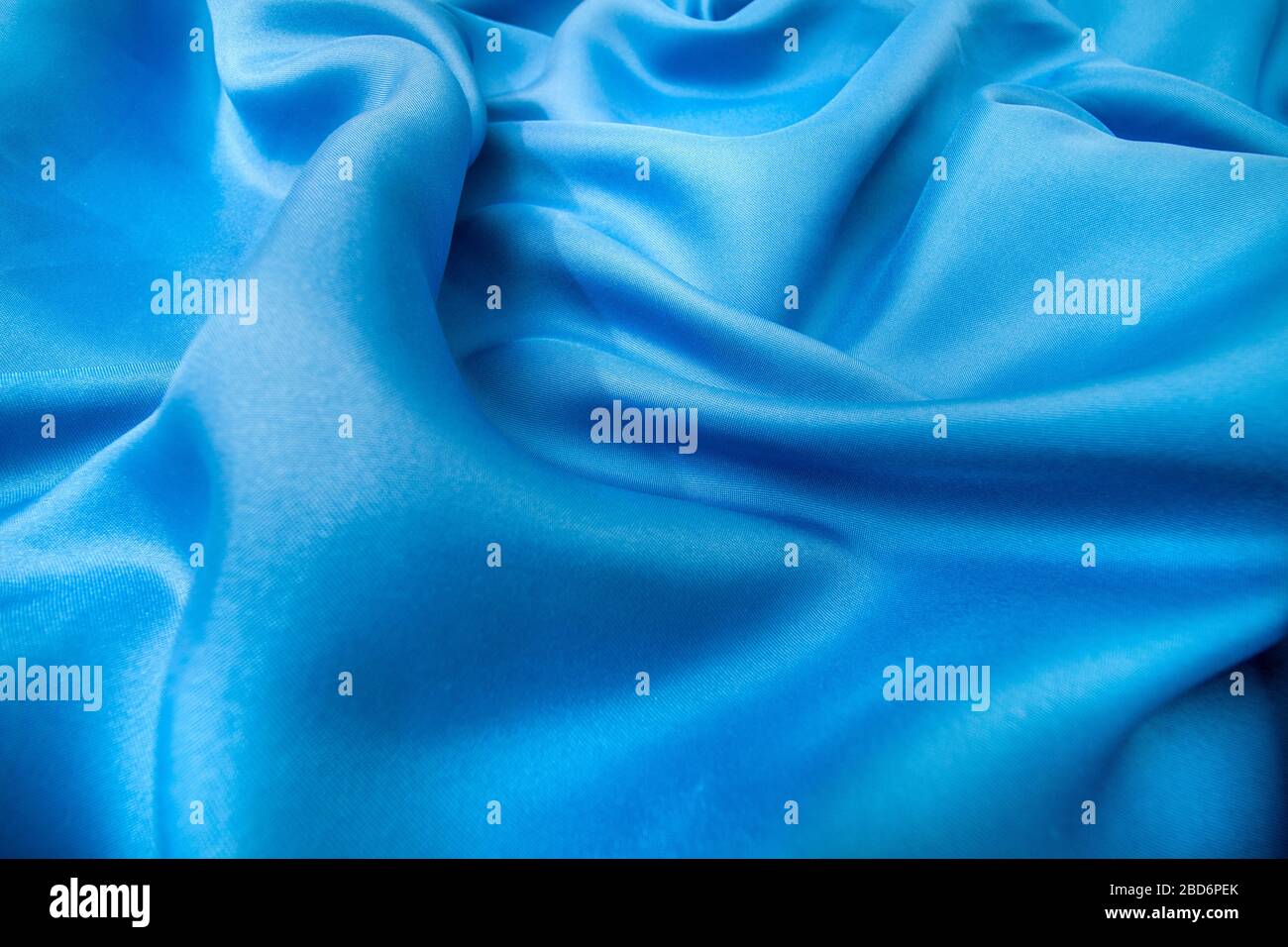 Wavy blue color silk fabric texture background Stock Photo - Alamy