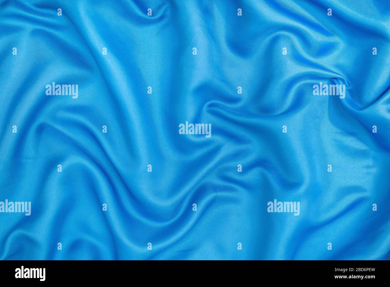 Wavy blue color silk fabric texture background Stock Photo - Alamy