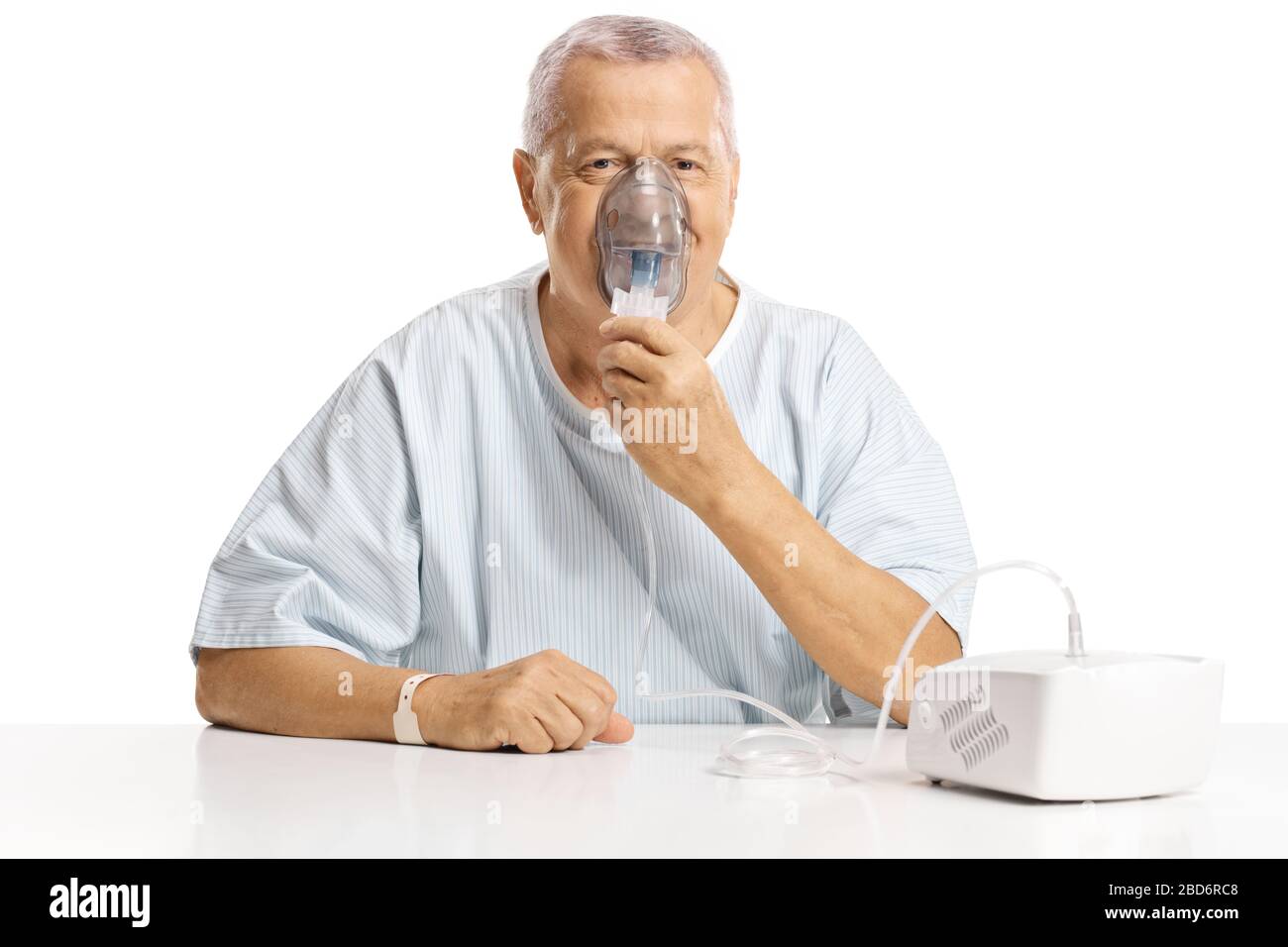 Elderly male patient using an inhalator isolated on white background ...