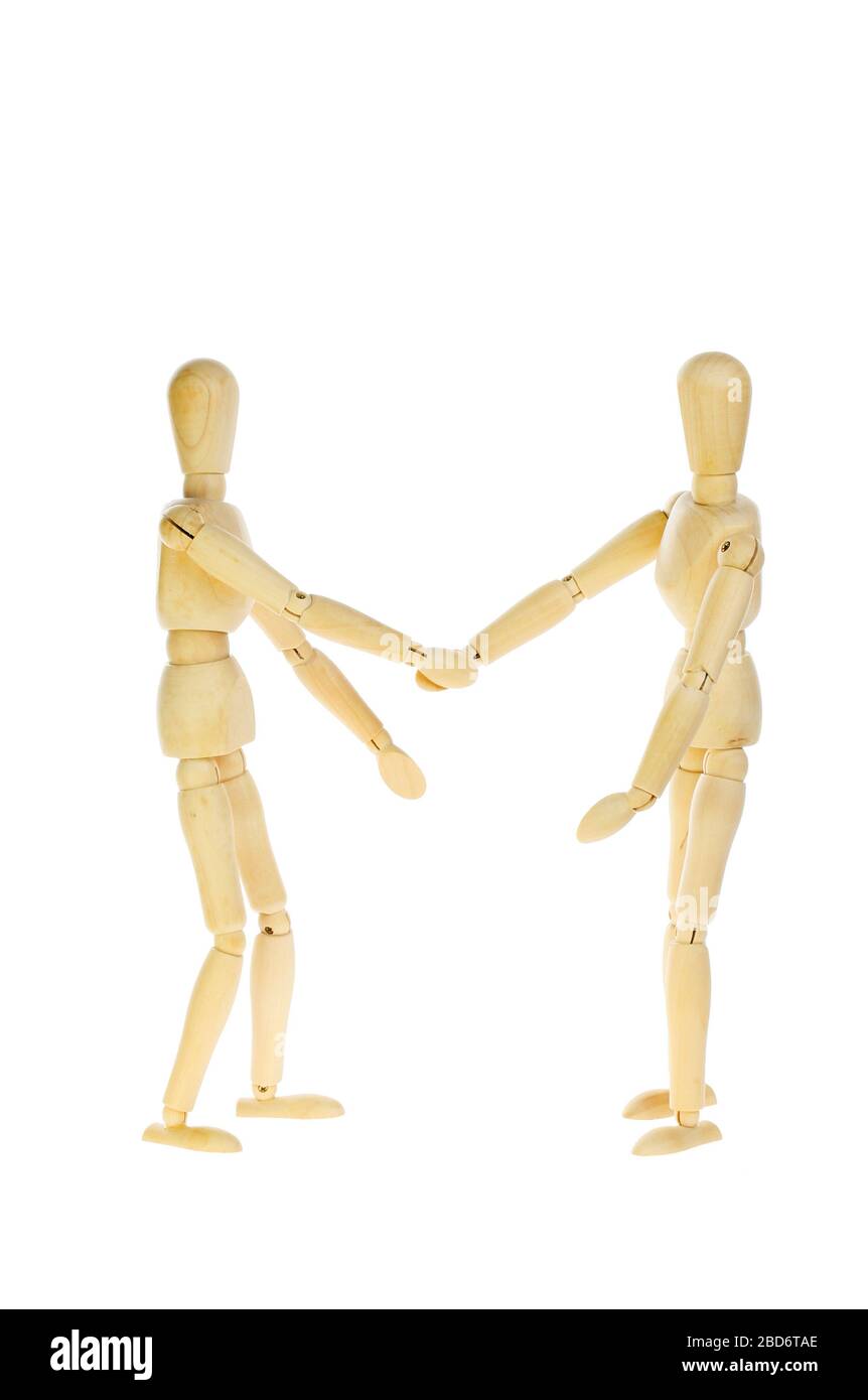 Two wooden artists mannikins shaking hands isolated against white Stock ...