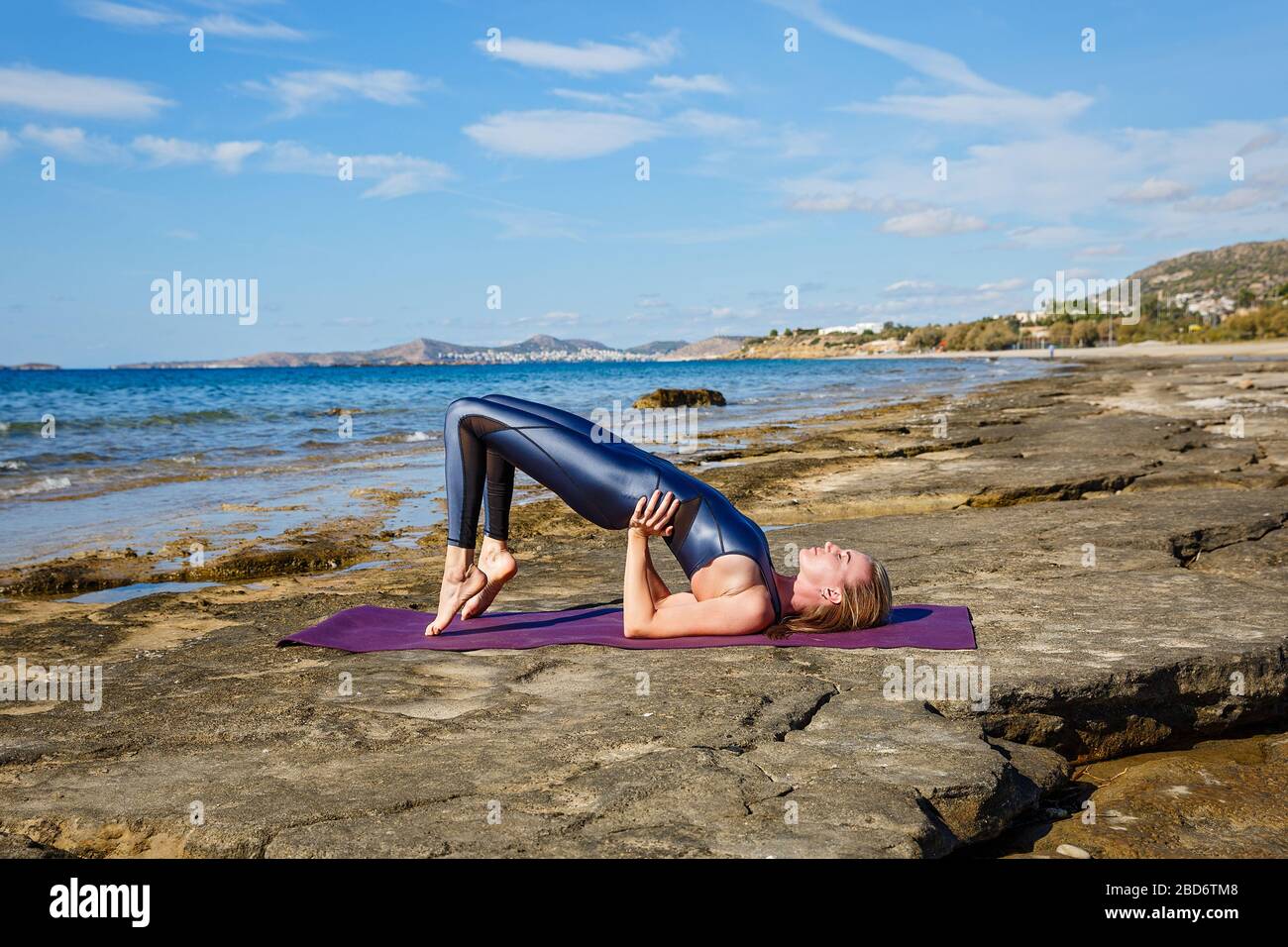 Young plastic woman doing sports exercises on the beach Stock Photo - Alamy