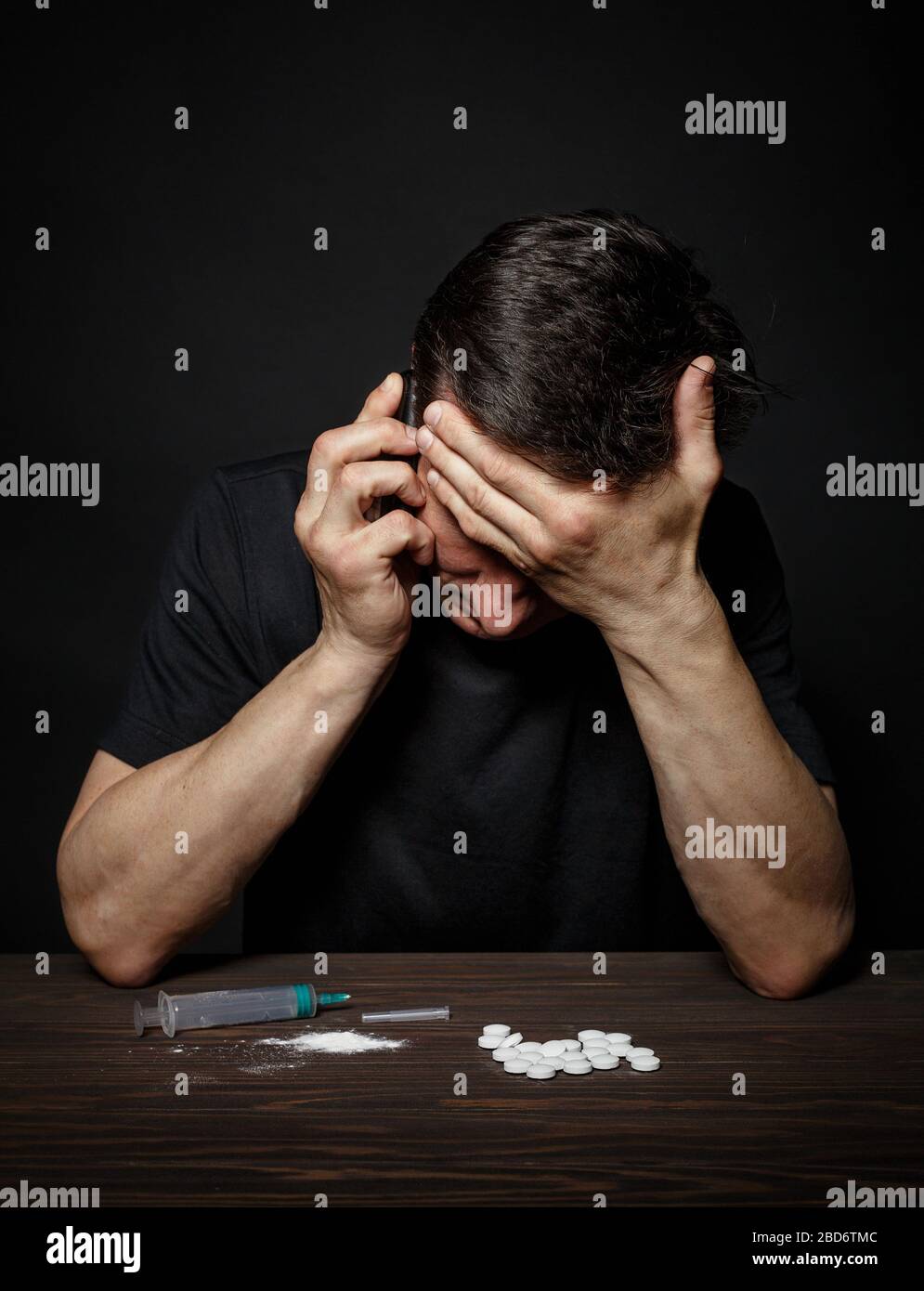 Man drug addict calls on the phone for help, a pose of desperation ...