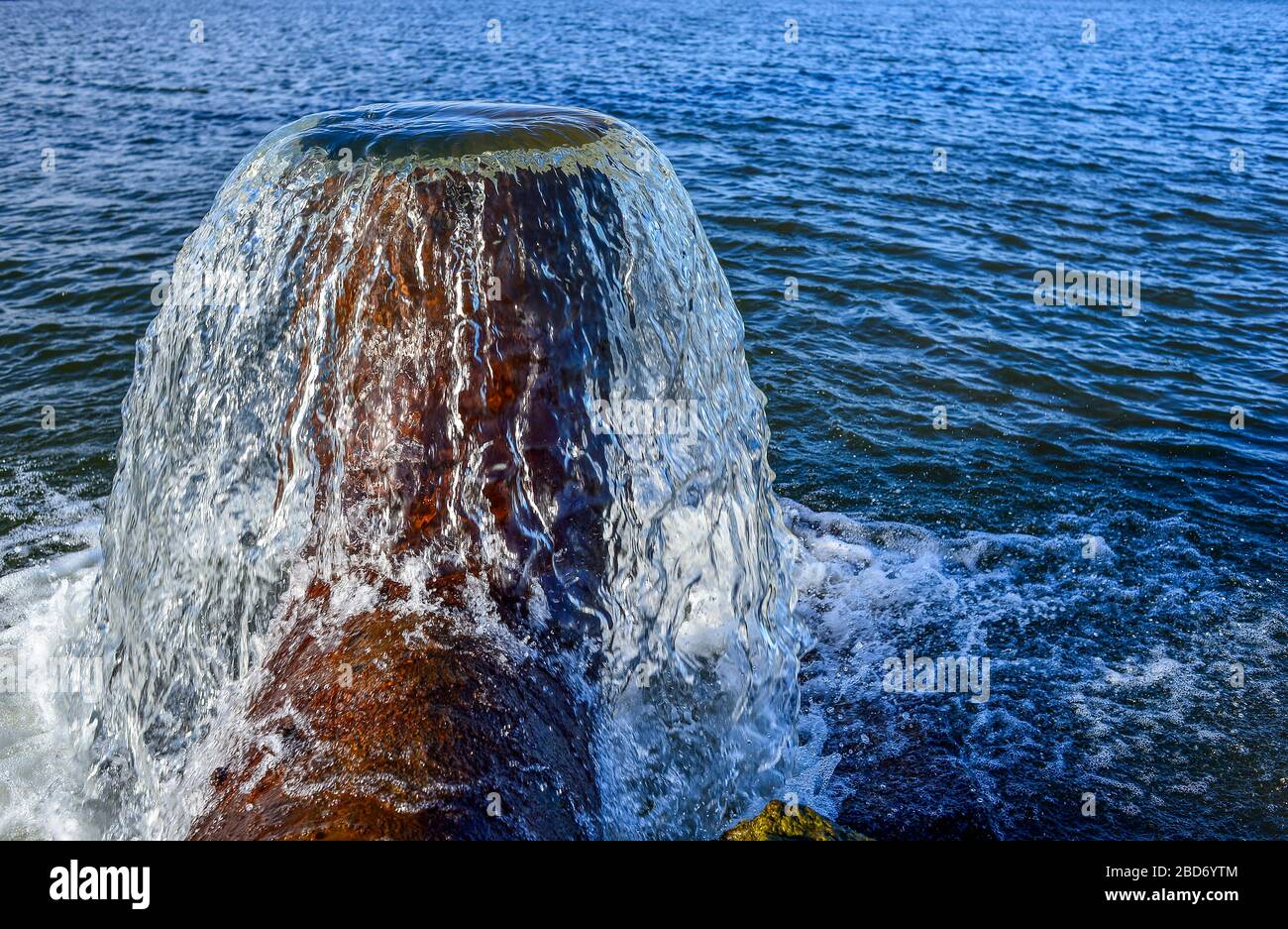 Vertical water flow from the pipe to the fish pond Stock Photo - Alamy