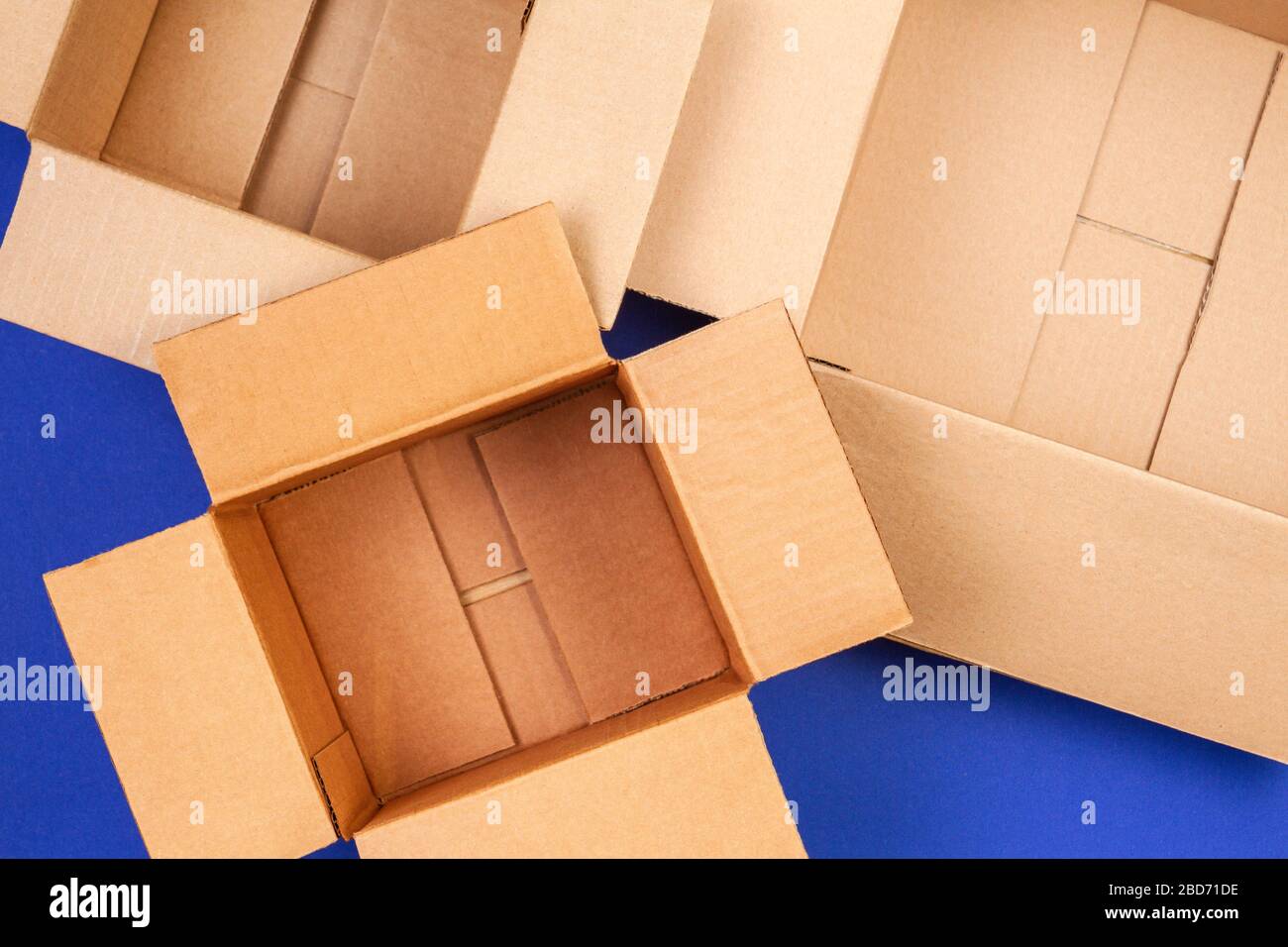 Empty open cardboard boxes on blue background Stock Photo - Alamy