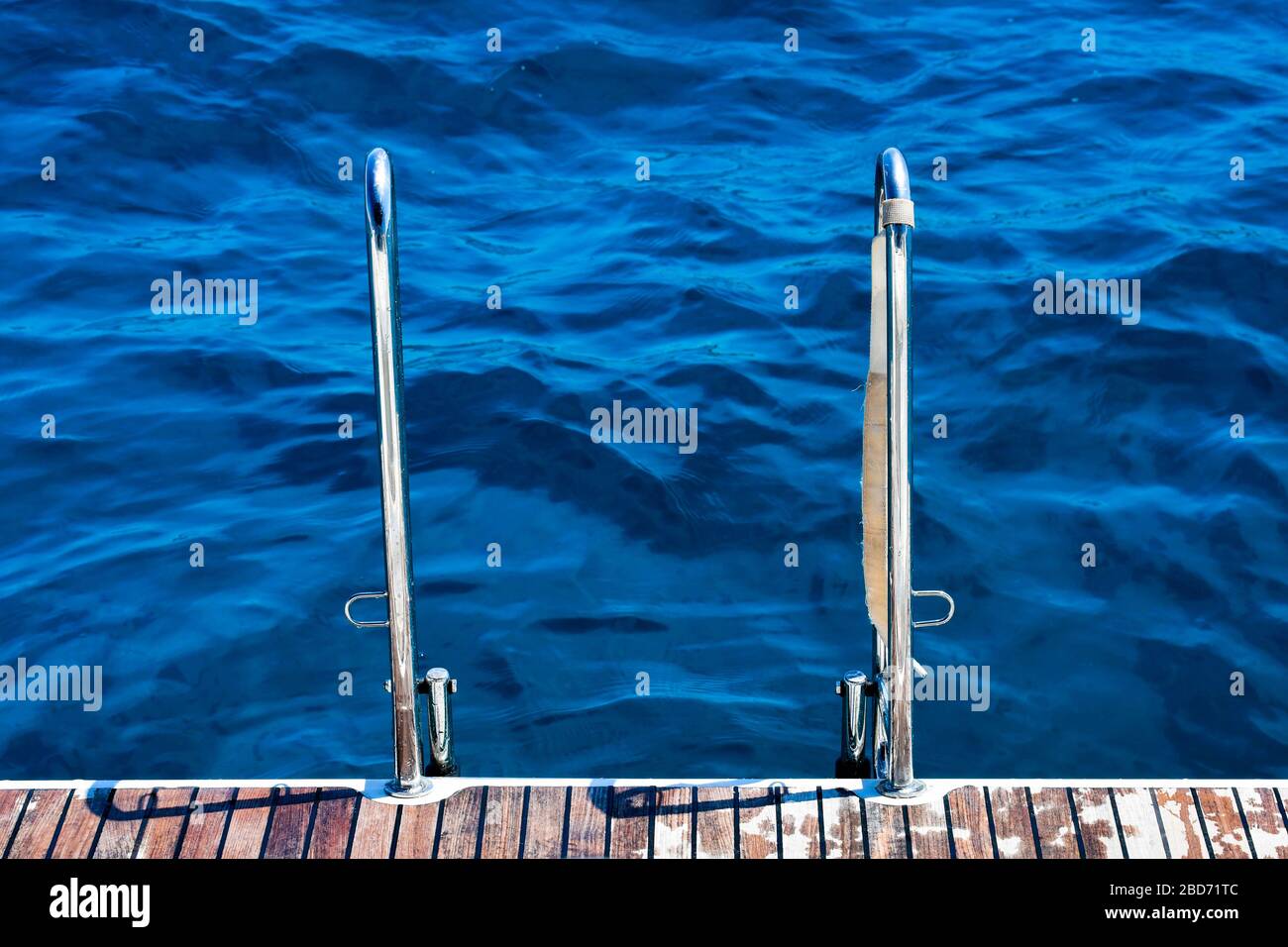 Chrome shinning aft wooden deck ladders on sailboat or yacht with ...