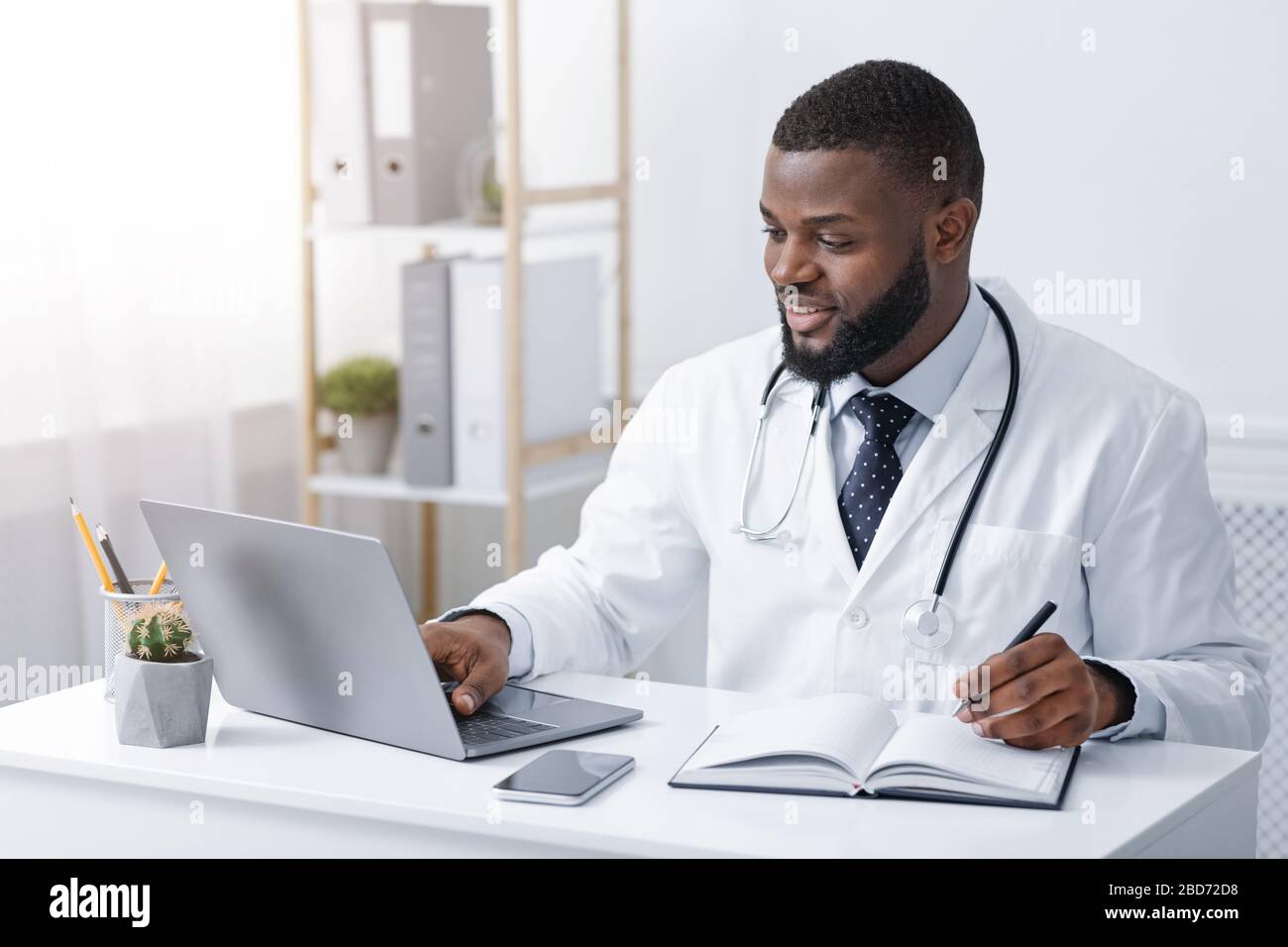 Cheerful doctor using laptop hi-res stock photography and images - Alamy