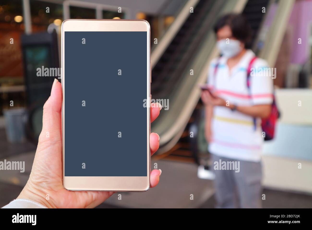 Closeup blank mobile phone screen in woman's hand with blurry man ...