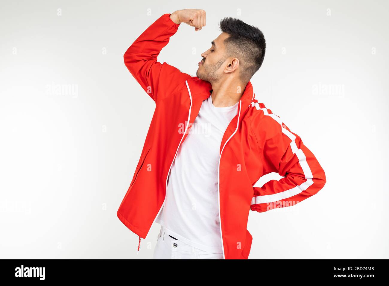 strong man in sports red shows his muscles on a white background with ...