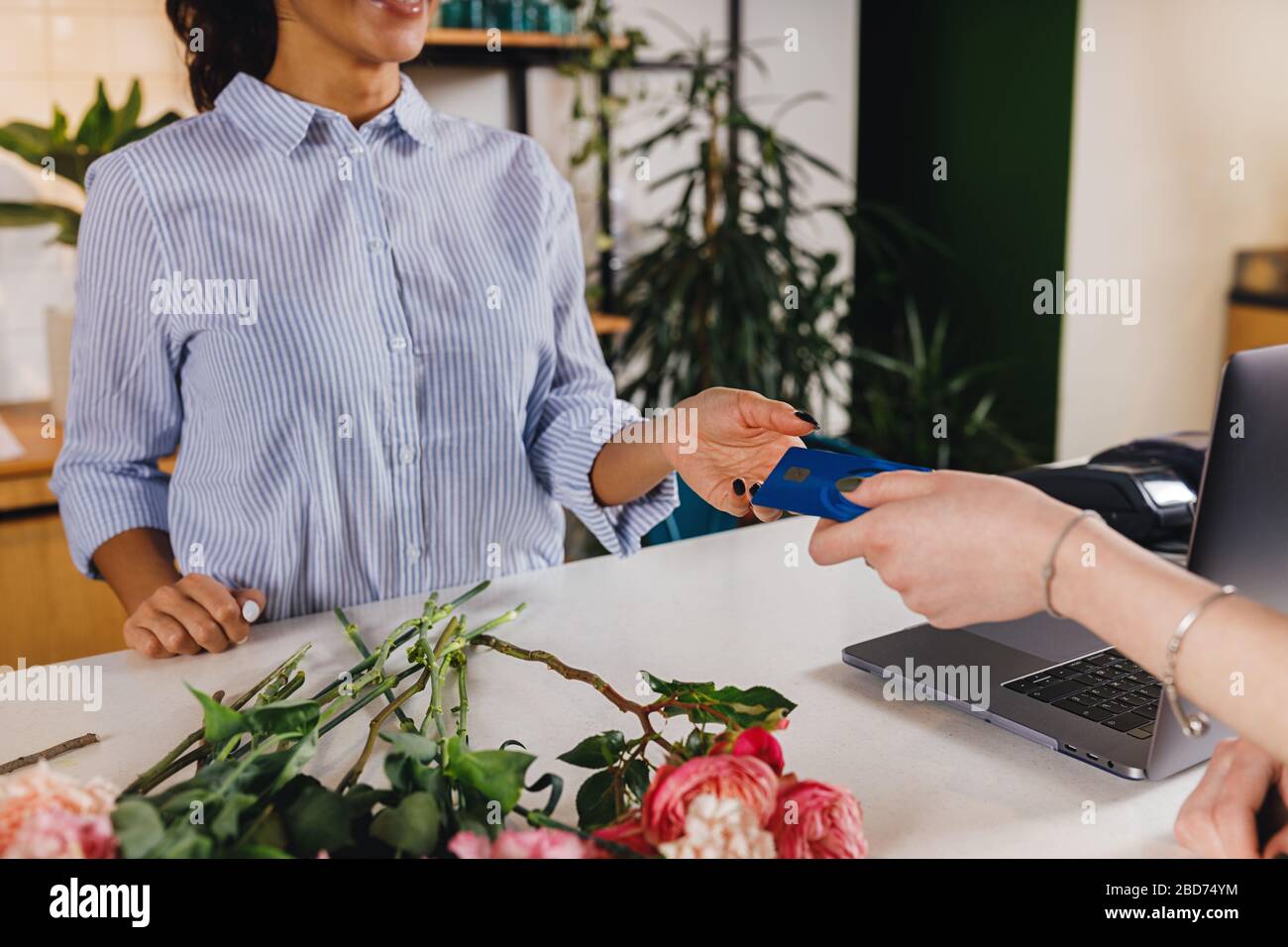 Unrecognizable woman entrepreneur taking card from the customer to make ...