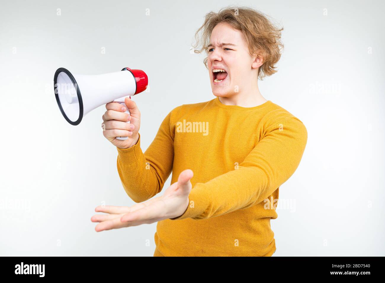 blond wavy guy shouting news into a loudspeaker on a white studio ...