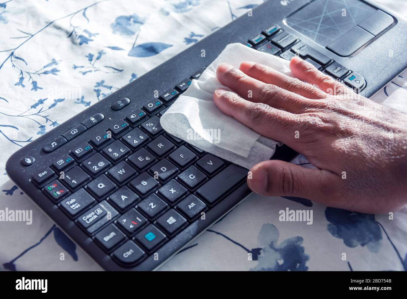 Male asian hand cleaning portable keyboard with anti bacterial wipes ...