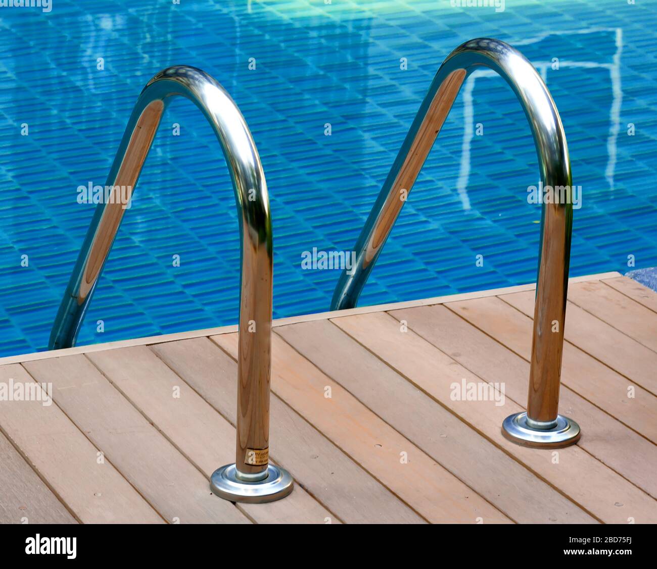 Chrome ladder rail on a swimming pool deck Stock Photo - Alamy