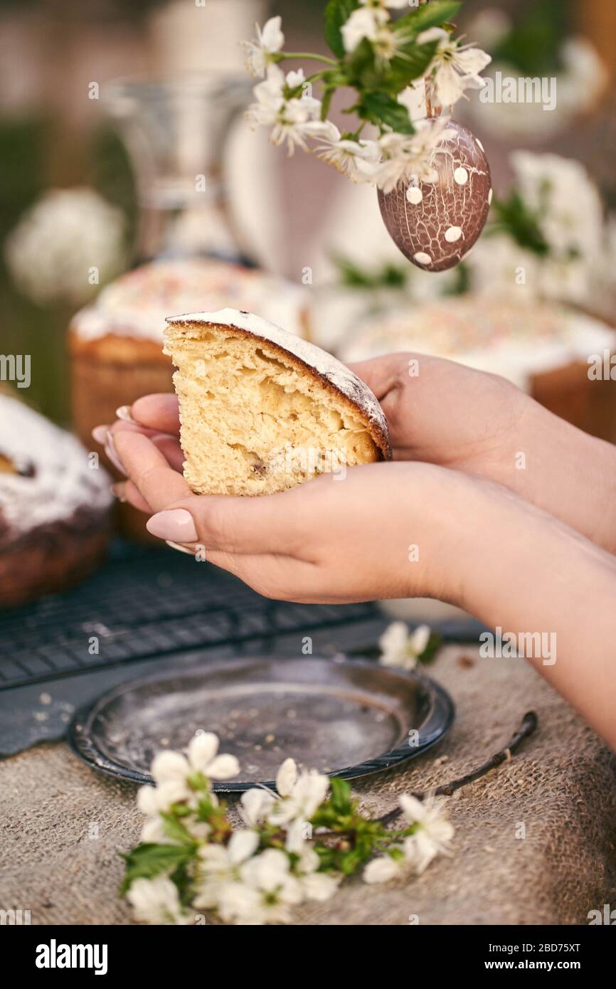 Traditional russian Easter cottage cheese dessert. Woman hands take a piece of orthodox paskha ...