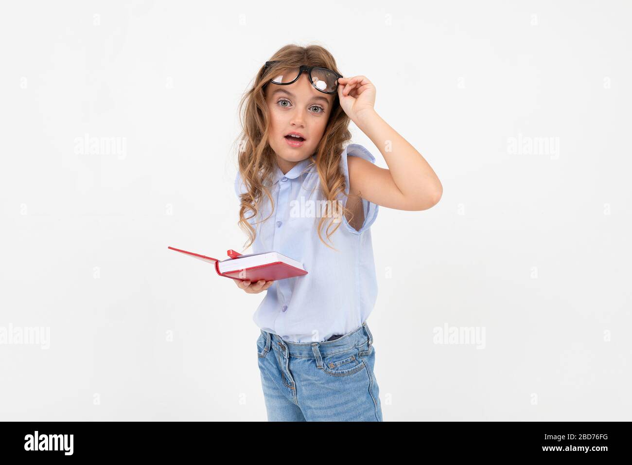 smart girl with glasses writes in a notebook on a white background with ...