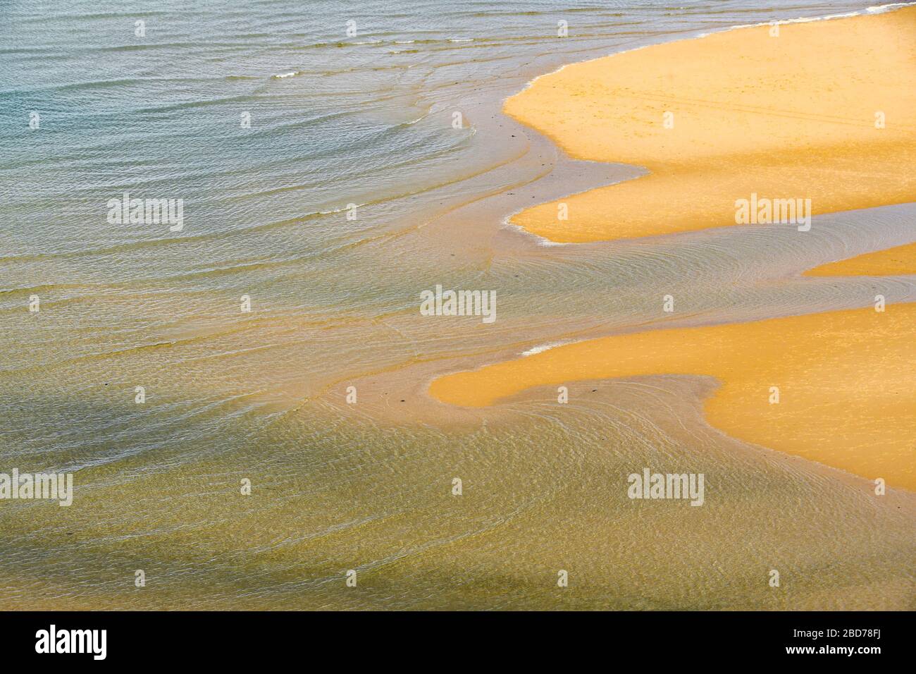 Pattern of waves and rippled water as the incoming tide covers ...