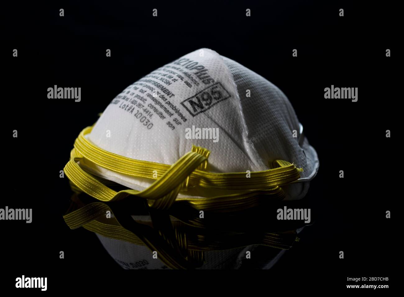 N95 medical mask close up isolated on black background. Respirator used ...