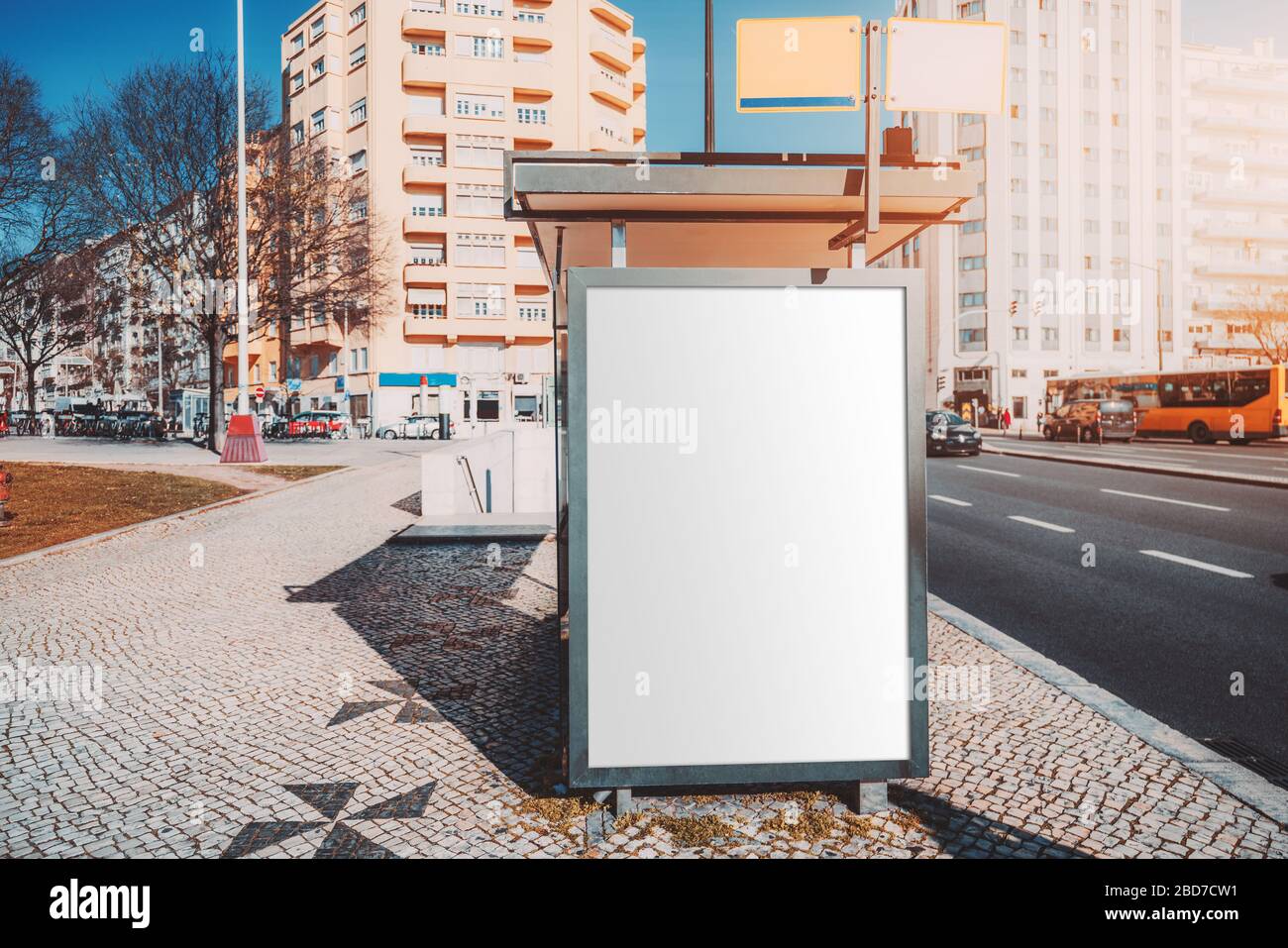 A bus stop near the road with a mockup of a blank advert poster on it ...