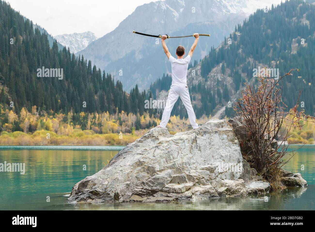 A man holds a Japanese sword katana above his head. Training combat ...