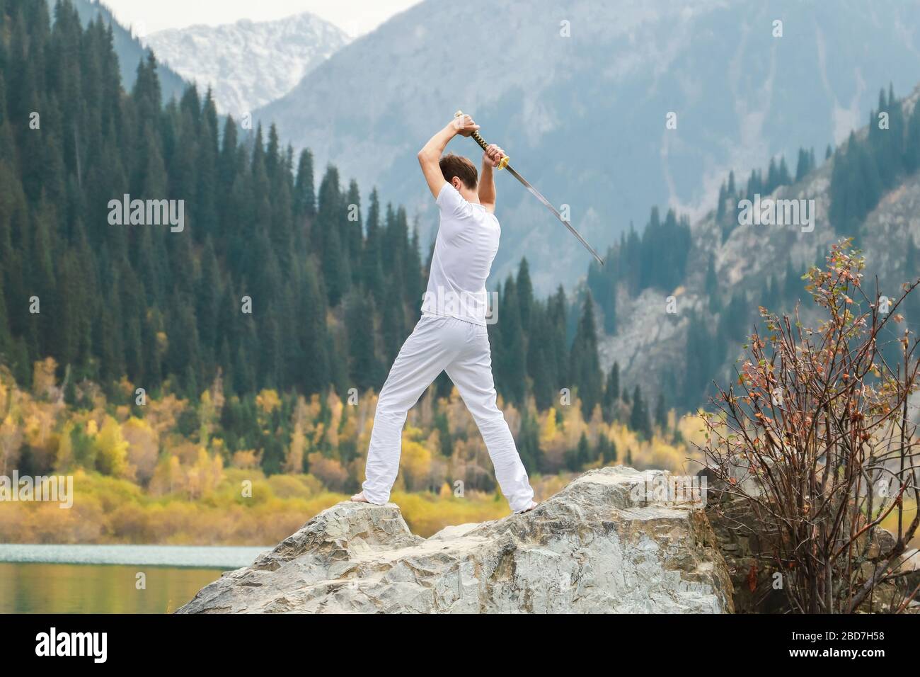 A man holds a Japanese sword katana above his head. Training combat ...