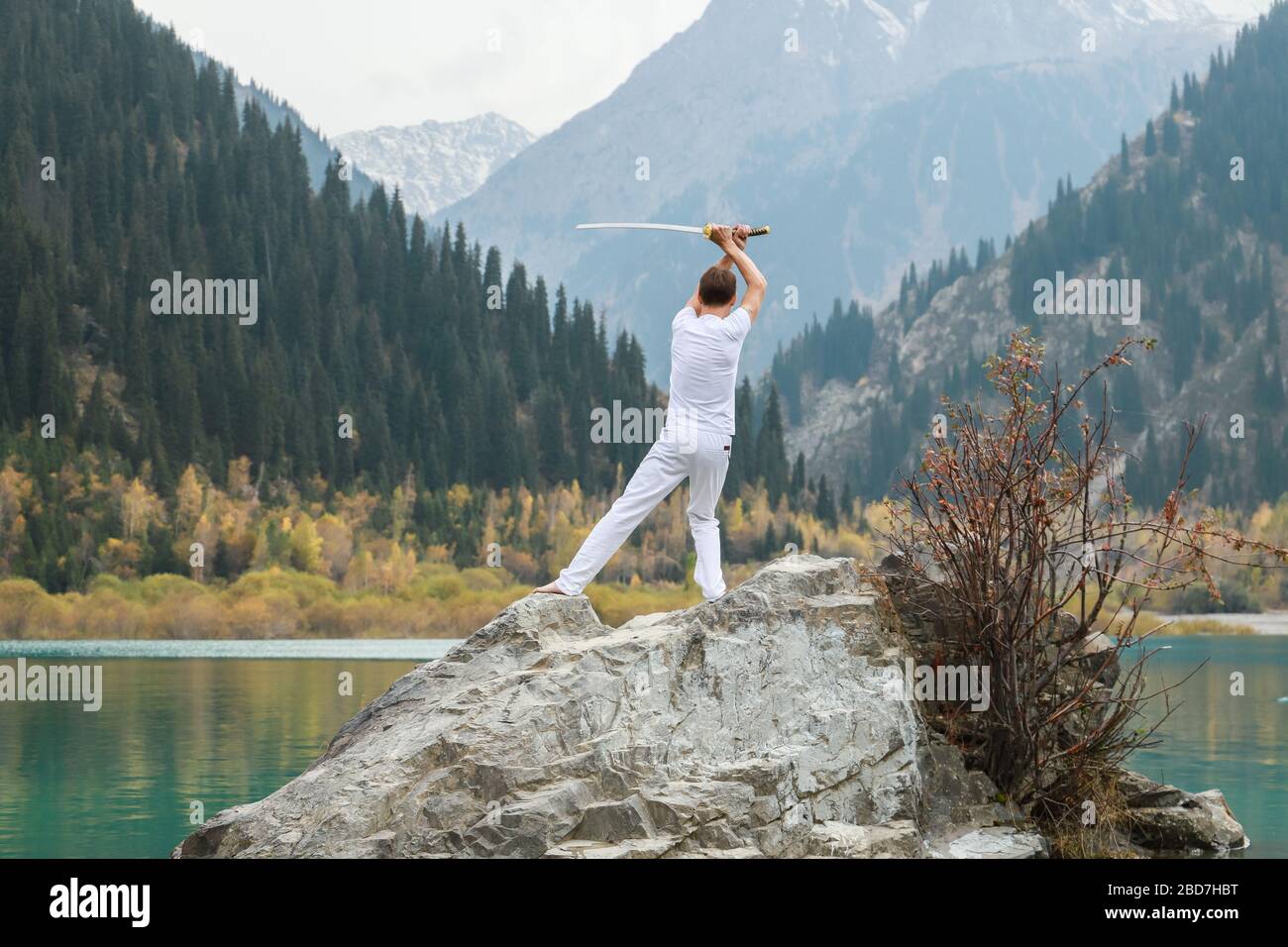 A man holds a Japanese sword katana above his head. Training combat ...