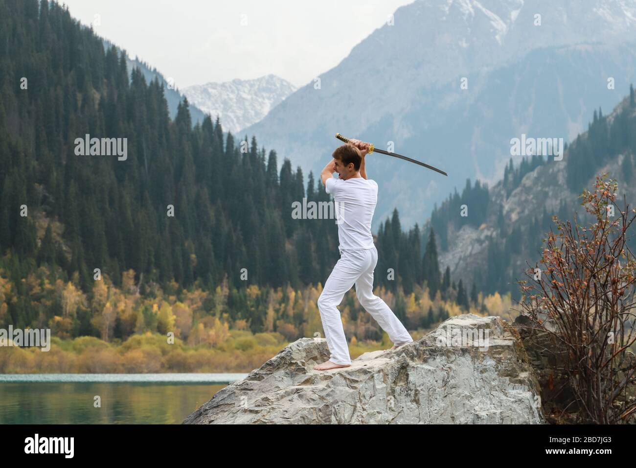 A man holds a Japanese sword katana above his head. Training combat ...