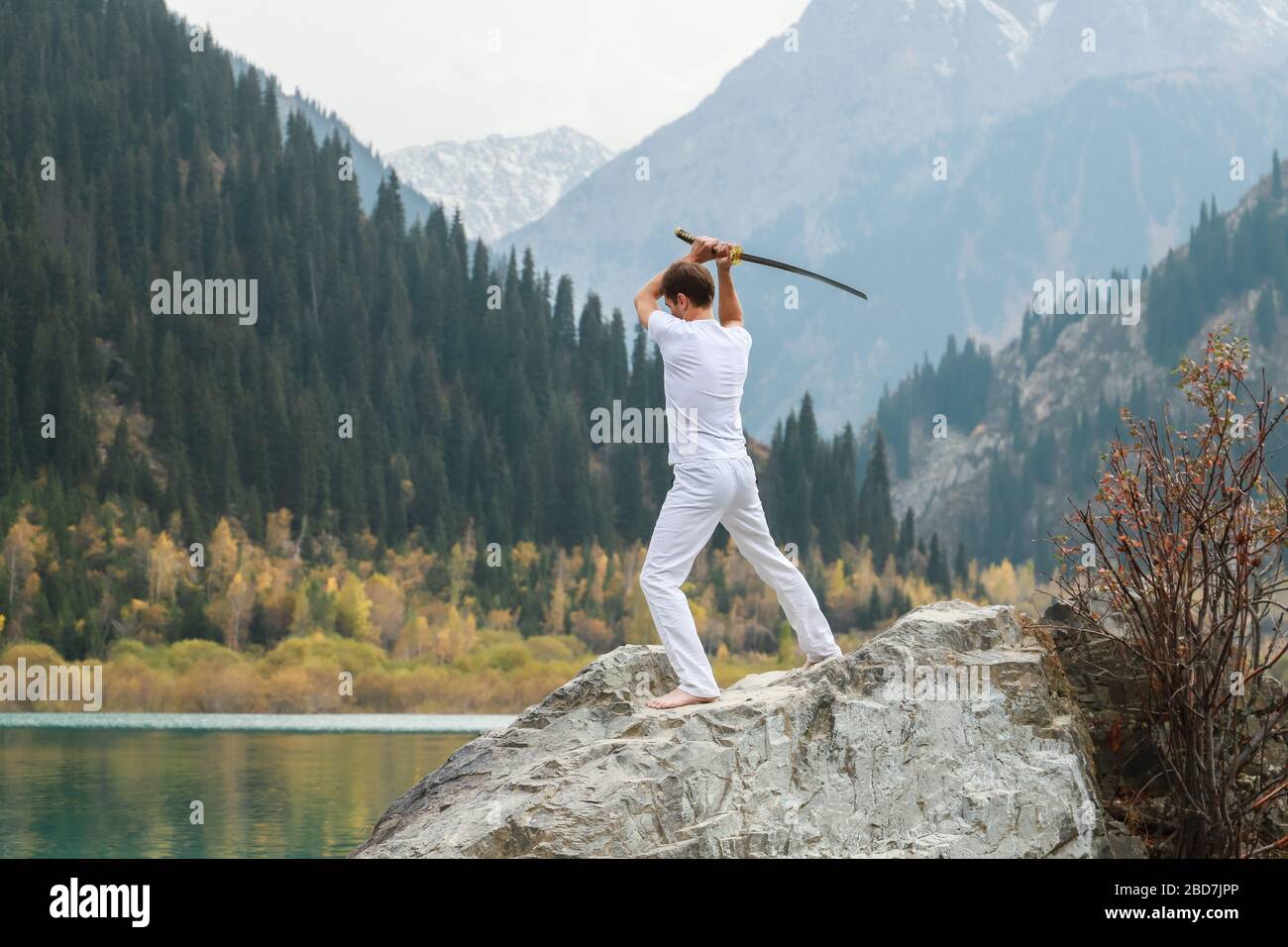 A man holds a Japanese sword katana above his head. Training combat ...