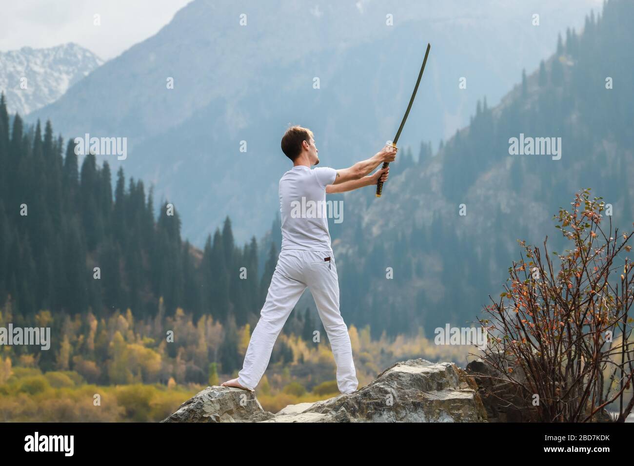 A man holds a Japanese sword katana above his head. Training combat ...