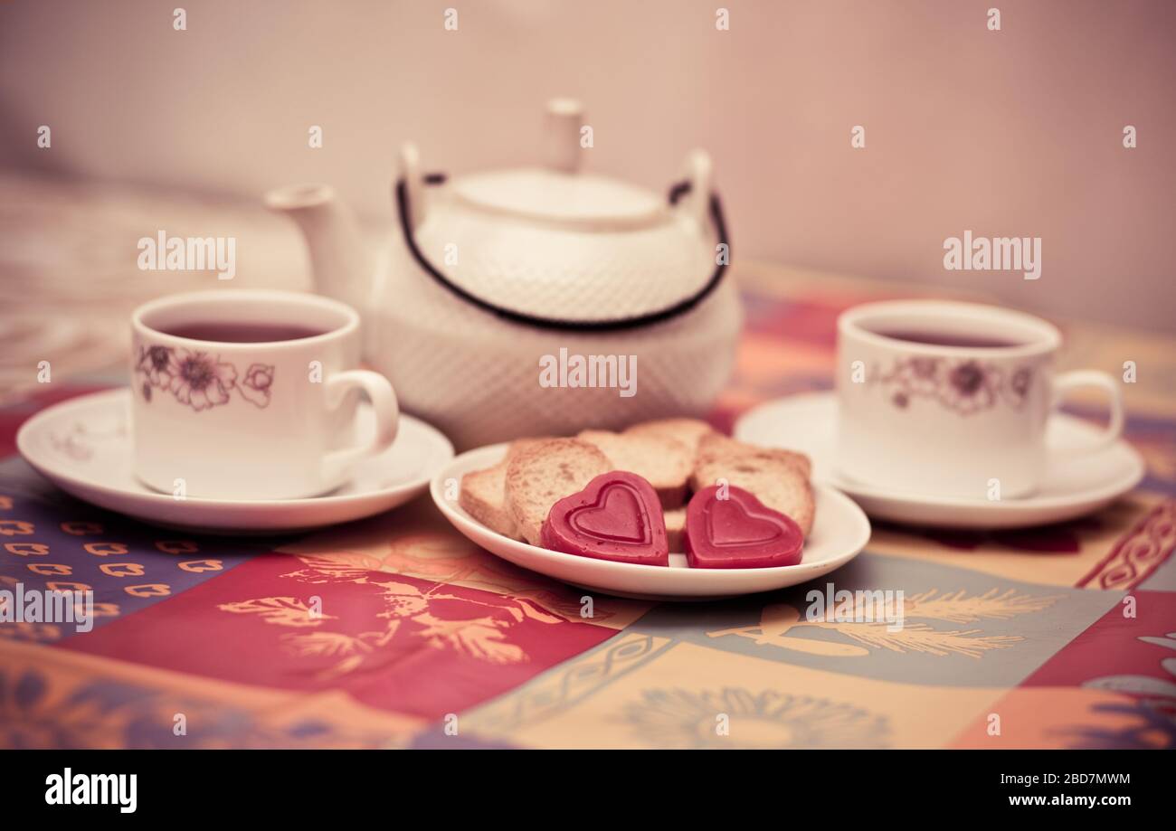 Time for a tea break. 2 cups of hot drink, tasty cookies, heart shaped ...