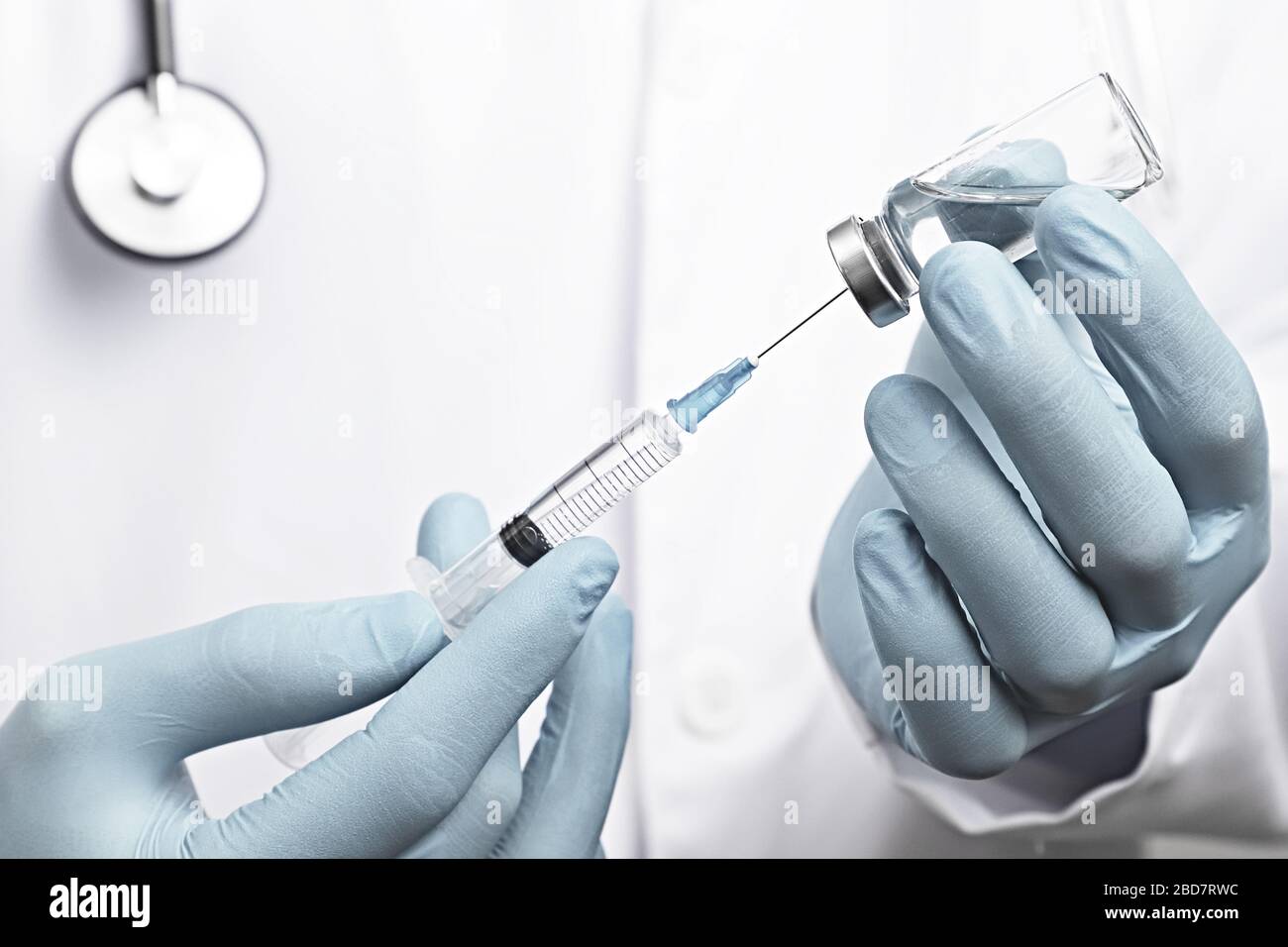 Close up doctor arm using syringe and ampoule, white robe dressed ...