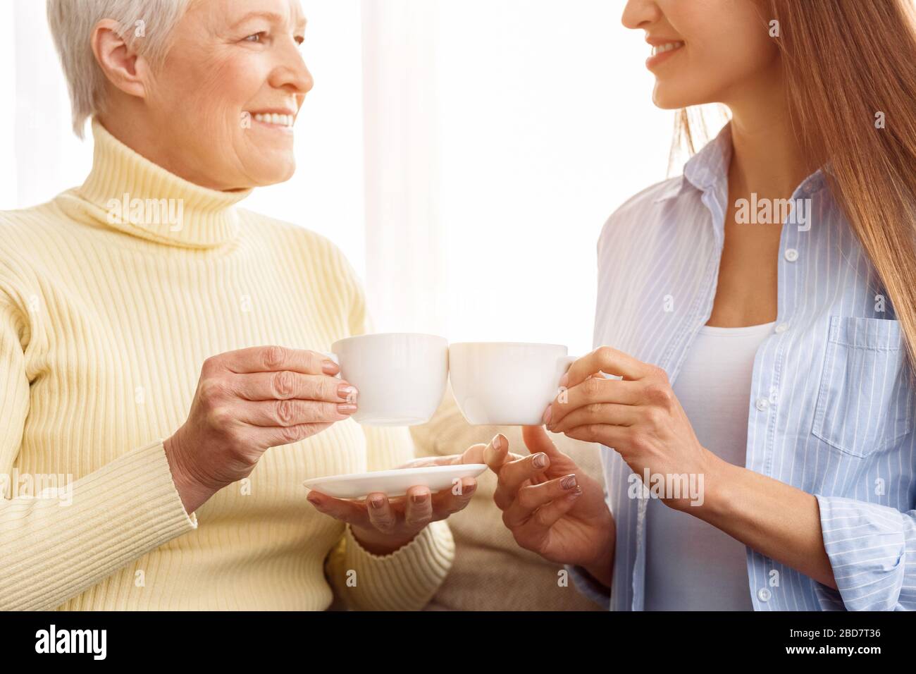 Happy mother and daughter toasting tea, enjoying breakfast Stock Photo ...