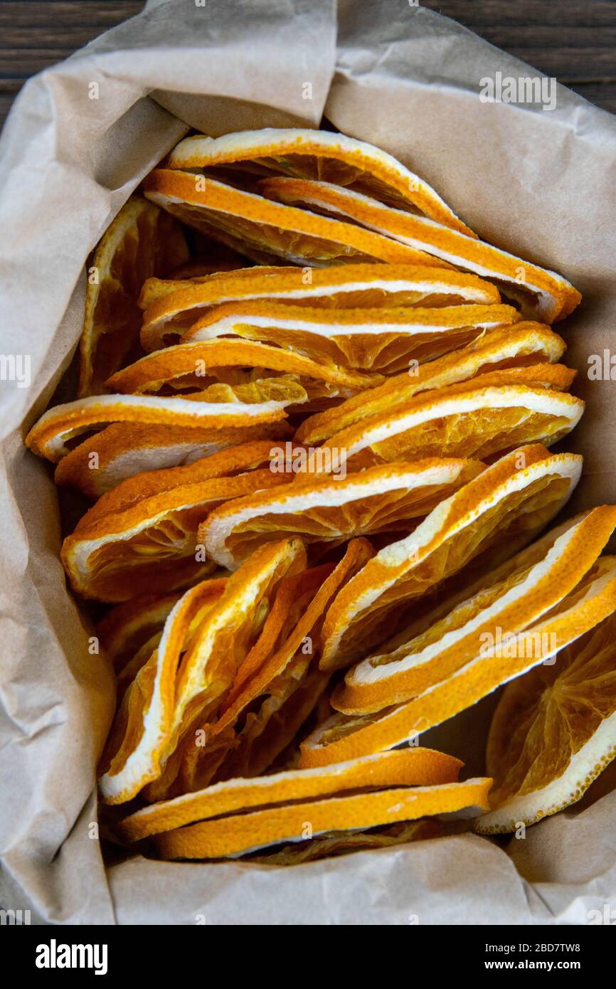 Fruit chips from orange slices in a paper bag. Top views, close-up ...
