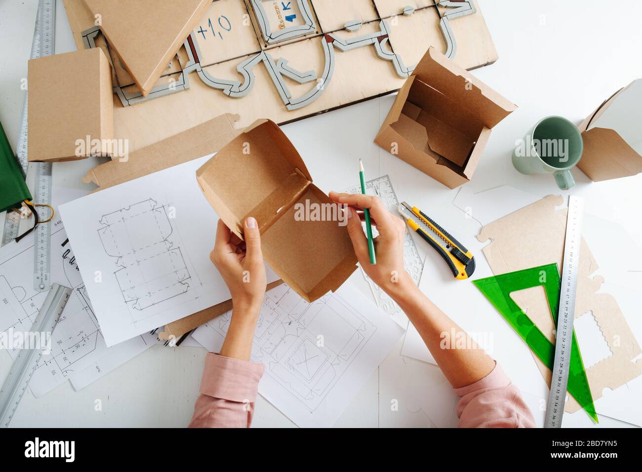 Box maker analysing box, prepared to make marks with a pencil Stock ...