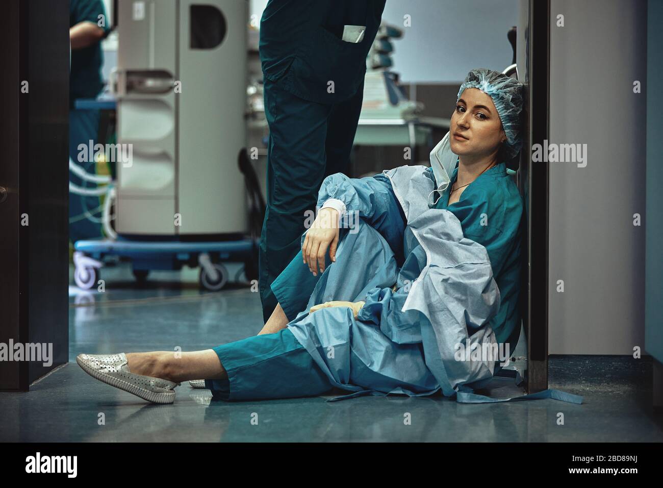 Tired doctor sitting after surgery in the hospital corridor. Great ...