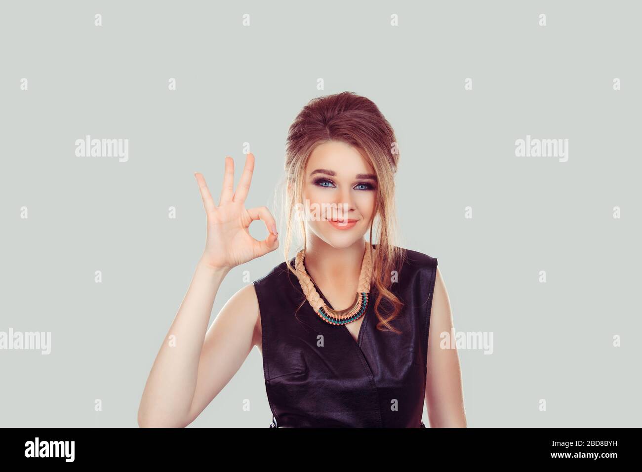 Everything will be alright. Beautiful young happy woman showing Ok sign ...