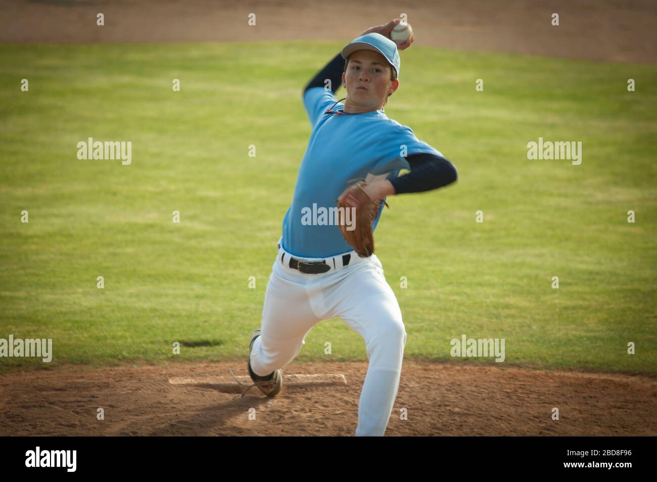 Pitcher in light blue and white jersey during wind up on a baseball ...