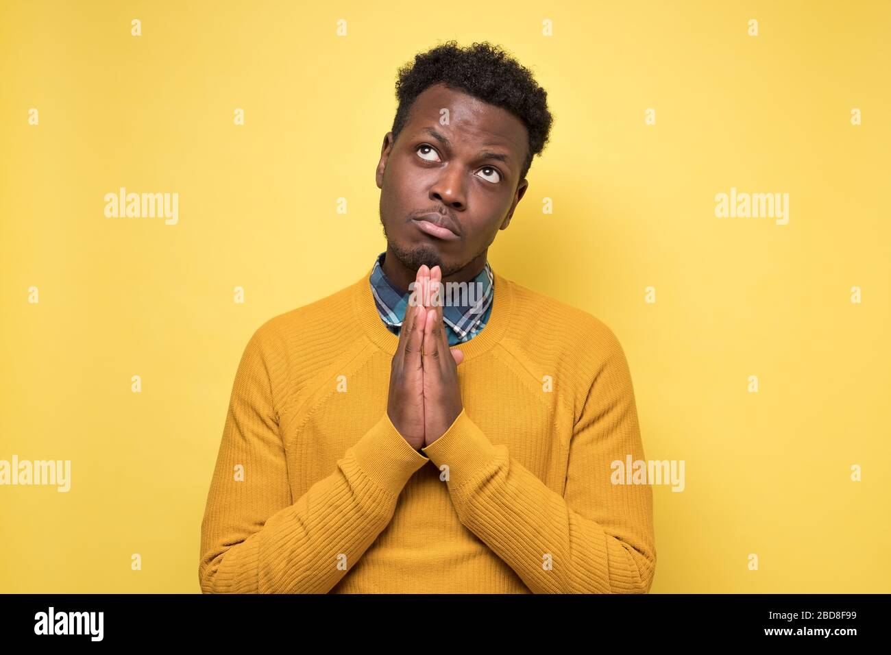 Afro American male pressing hands together, having guilty look Stock ...