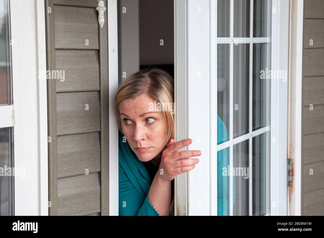 Woman window peek afraid hi-res stock photography and images - Alamy